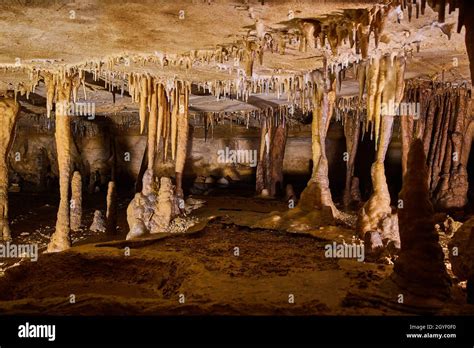 Formations Of Stalagmites And Stalactites In Cave With Narrow Walking