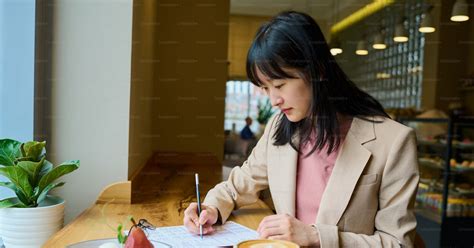 커피숍에서 디저트와 커피가 있는 테이블에 앉아 입사 지원서를 작성하는 젊은 후보자 사진 Unsplash의 커피숍 이미지