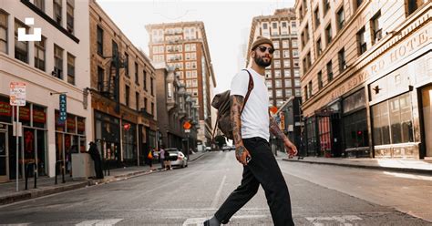 흰색 긴팔 셔츠와 검은 바지를 입은 남자가 낮에 도로에 서 있다 사진 Unsplash의 무료 로스앤젤레스 이미지