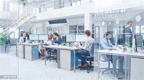 데스크톱 컴퓨터에서 일하는 젊은 전문가의 밝은 바쁜 사무실 행에서 말하기 클라이언트 지원 고객과의 통신 모니터링 통계 컴퓨터