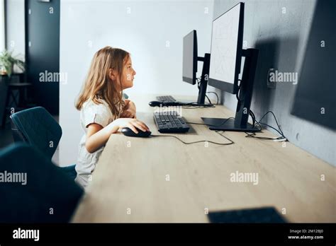 Engaged Absorbed Schoolgirl Learning To Use Technology In Classroom At