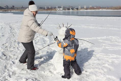 A Mulher E O Rapaz Pequeno Que Constroem Um Boneco De Neve Imagem De Stock Imagem De