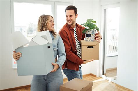 새 아파트에서 소지품으로 가득 찬 상자를 들고 춤을 추는 젊은 웃는 커플 이주 개념에 대한 스톡 사진 및 기타 이미지 이주 개념 행복 상자 Istock