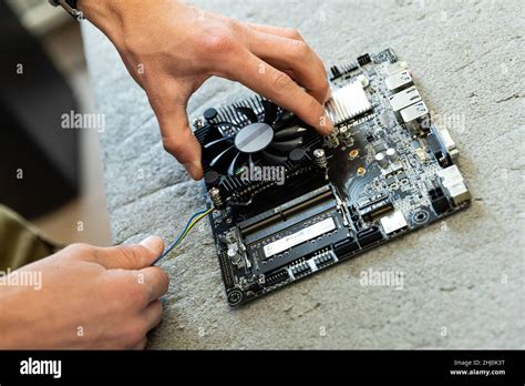 Photo Of Hand Assembles A Computer Monitor System Block On An Conveyor Belt At A Monoblock