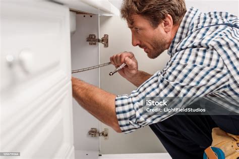 부엌 싱크대를 고정하는 동안 금속 파이프를 들고 배관공의 측면 보기 가정 주방에 대한 스톡 사진 및 기타 이미지 가정 주방 가정의 방 공구벨트 Istock