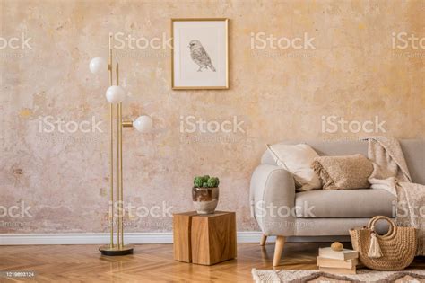 디자인 회색 소파 나무 커피 테이블 선반 큐브 카펫 등나무 푸프 식물 사진 프레임 테이블 램프와 가정 장식우아한 액세서리와 거실 인테리어에서 세련된 Scandi 퇴비 0명에