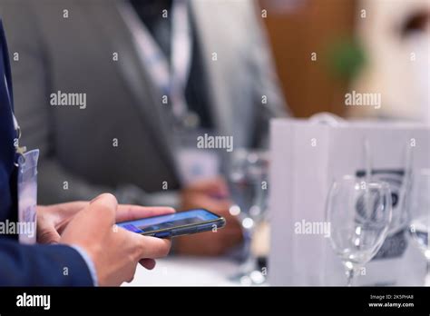 Conference Staff Member Scan A QR Code From Attendee Upon Arrival To Check In Site Stock Photo