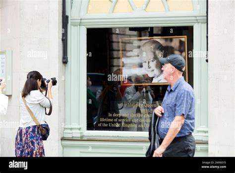 A Portrait Of Queen Elizabeth Ii Is Displayed In The Shop Window