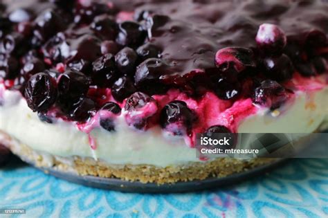 버터 비스킷 베이스와 블랙 커런트 치즈 케이크 블루 플레이트의 이미지 레스토랑 저녁 식사 후 디저트 푸딩 바닐라 마스카포네 크림 치즈 체리 잼 쿨리 토핑 신선한 블랙 커런트