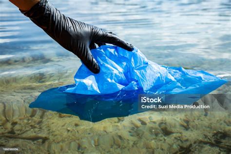 고무 장갑에 손을 들고 맑은 물에 떠있는 사용 된 비닐 봉지 가방에 대한 스톡 사진 및 기타 이미지 가방 기후 변화 기후 묘사 Istock