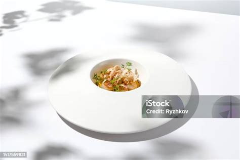 구운 바다 가리비와 콜리 플라워를 곁들인 전채 가리비와 야채를 곁들인 크리미한 리조또 거친 그림자가있는 흰색 세라믹 플레이트에 구운 바다 가리비 해산물 메뉴 여름 음식 0