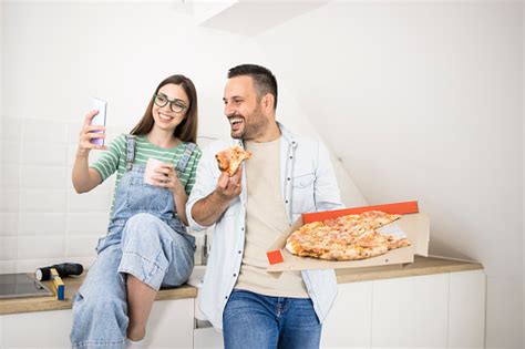 행복한 부부는 셀카를 찍고 피자를 먹고 새로운 집을 준비하는 동안 25 29세에 대한 스톡 사진 및 기타 이미지 25 29세