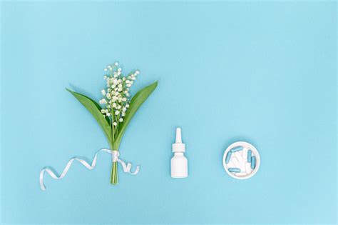 계절의 봄과 여름의 꽃이 피는 알레르기의 시작에 Ð 흰색 비강 스프레이 와 알약 파란색 배경에 향기로운 꽃 복사 공간이있는 창조적 인 평면 평신도 구성 개념에 대한 스톡