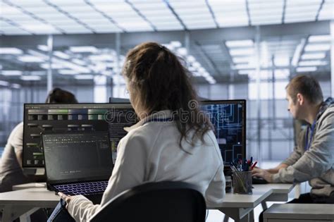 Woman Running Code On Laptop To Upgrade Artificial Intelligence Rigs