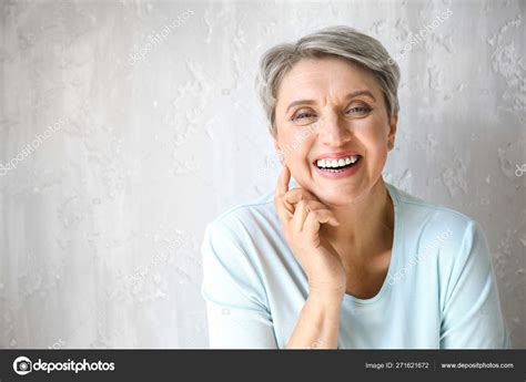 Портрет красивой зрелой женщины на сером фоне — Стоковое фото © Serezniy 271621672