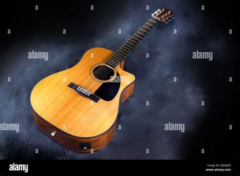 Acoustic Classical Yellow Six String Guitar With Black Pickguard In Smoke On Black Isolated