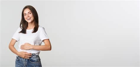 Free Photo Satisfied Smiling Brunette Girl Rubbing Belly After Eating