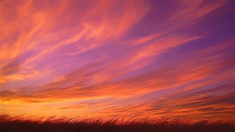 Premium AI Image A Sunset With A Red Sky And Clouds In The Background