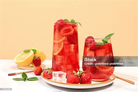 딸기 아이스티 또는 민트 레몬 칵테일은 상쾌한 여름 음료 레시피입니다 가벼운 콘크리트 테이블에 베리 과일 레모네이드가 담긴 안경 디톡스 다이어트와 체중 감량 개념 레스토랑