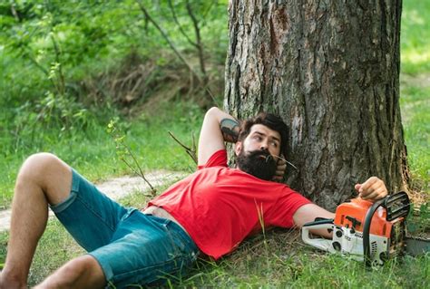 Premium Photo Resting After Hard Work Lumberjack Worker With Chainsaw