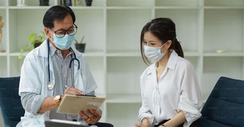 전문 연령의 남성 의사가 여성 환자의 증상에 대해 문의하고 의료 기록을 작성합니다 사진 Unsplash의 일반 개업의 이미지