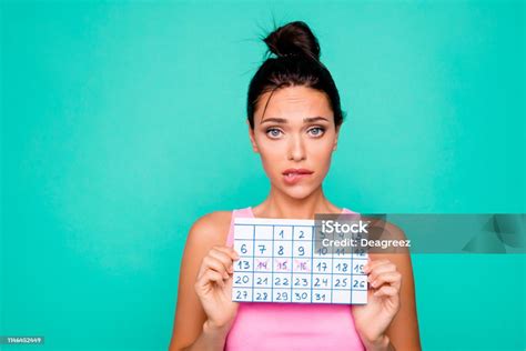 클로즈업 사진 아름 다운 놀라운 그녀는 그녀의 여자 재미 있는 머리 물린 입술 입 홀드 손 팔 종이 달력 불편 상황 죄송 착용 캐주얼 핑크 탱크 탑 고립 된 청록 청록색