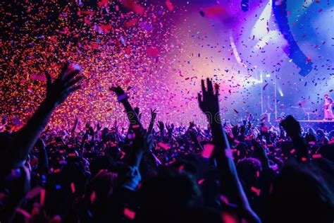 A Massive Crowd Of People At A Concert Celebrating With Confetti