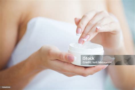 손 피부 관리입니다 여성 손 크림 튜브를 들고 자연 매니큐어 손톱 화장품 핸드 크림을 적용 하는 부드러운 실크 건강 한 피부에 아름 다운 여자 손 클로즈업 깨끗한에 대한