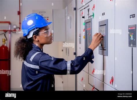 Electrical Young Asian Woman Engineer Examining Maintenance Cabinet System Electric And Using
