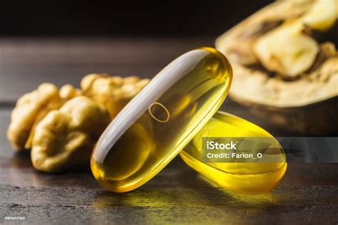 노란색 캡슐 오메가 3 지방산 어두운 나무 테이블 매크로 이미지에 호두 커널 생선 기름 0명에 대한 스톡 사진 및 기타 이미지