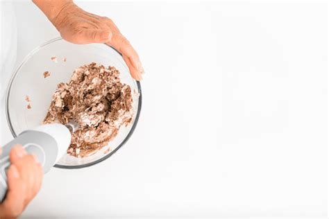 크림 파이 충전을 준비하는 시니어 여성의 손 흰색 테이블에 부엌에서 믹서기 믹서를 사용하여 주부 채찍질 성분의 최고 보기 텍스트 공간을 복사 은퇴한 여자 요리 취미 가정