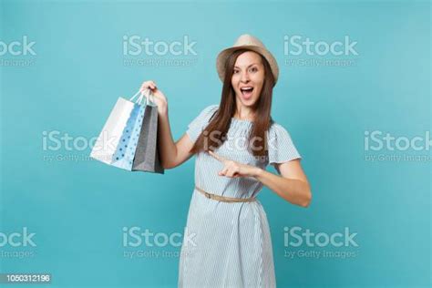 초상화 유행 웃는 아름 다운 백인 여자 여름에 드레스 밀 짚 모자 블루 파스텔 배경에 고립 쇼핑 후 구매와 패키지 가방을 들고 광고에 대 한 공간을 복사 합니다 가방에 대한
