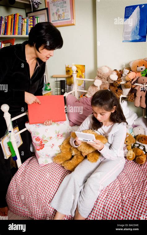 Girl Operating A Personal Data Assistant With Her Mother Standing