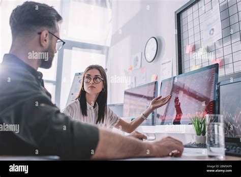 selective focus of data analyst pointing with hand on computer monitor