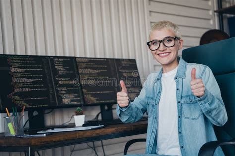 confident female programmer giving thumbs up in a modern office with
