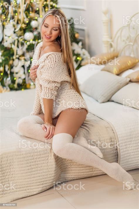 아름 다운 젊은 여 자가 입고 니트 흰색 스웨터 및 스타킹 새 해 나무 근처에 앉아 12월에 대한 스톡 사진 및 기타 이미지 12월 가정 생활 겨울 Istock