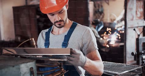 대형 폐기물 재활용 공장에서 안전모를 쓴 젊은 노동자의 초상화 엔지니어는 기계 및 기타 장비의 작업을 모니터링합니다 사진 Unsplash의 우크라이나 이미지