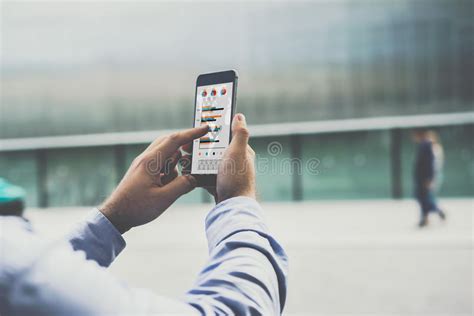 Close Up Of Smartphone With Graphs Diagrams And Charts On Screen In Hands Of Businessman