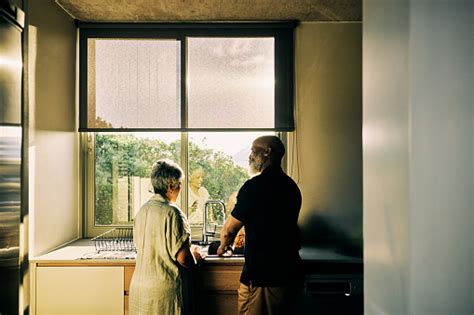 현대 가정 부엌에서 웃음을 나누는 활동적인 은퇴 한 아프리카 계 미국인 커플 설거지에 대한 스톡 사진 및 기타 이미지 설거지