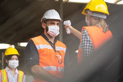 Temperature Measurement With Employee Temperature Meter Before Entering Work At Factory