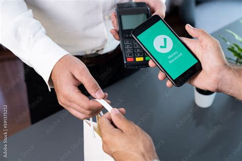 Hand Holding Smartphone With NFC QR Code Device Scanning Contactless Payment Code For Fast