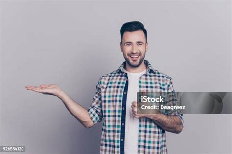 광고 개념입니다 명랑 전문 성공 Brunet 남자 캐주얼 복장 몸짓 엄지 제시 하는 새로운 제품 손바닥에 회색 배경 위에 복사 공간을 보여주는의 초상화 손에 대한 스톡 사진