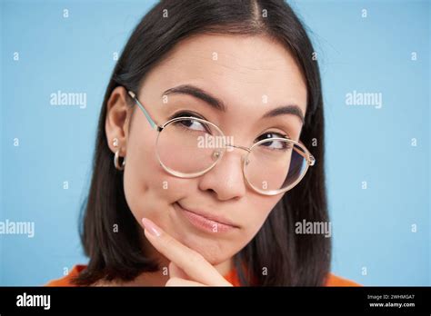 Portrait Of Japanese Woman In Glasses Looks Thoughtful Ponders