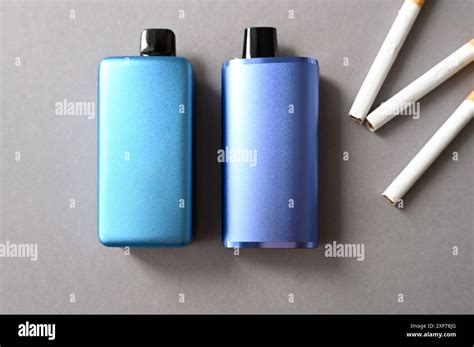 Two Electronic Cigarettes On Table With Analog Cigarettes Conceptual