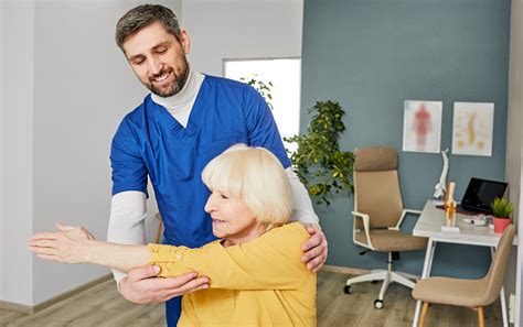 팔꿈치 관절에 부상을 입은 수석 여성 관절 통증 물리 치료사가 재활 중에 여성의 손을 잡고 있습니다 25 29세에 대한 스톡 사진 및 기타 이미지 Istock