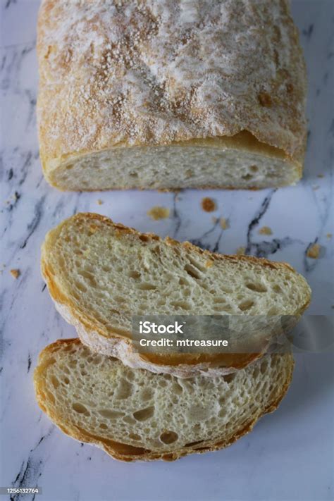 질감있는 디테일 황금갈색 오븐에서 신선한 슬라이스로 자른 바삭바삭한 빵 대리석 효과 배경 높은 뷰를 보여주는 슬라이스 수제 시아바타 빵 덩어리의 이미지 0명에 대한 스톡