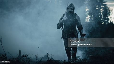 숲을 행진 하는 외로운 중세 전사 마지막 생존 십자군 군인 전신 갑옷을 입고 기사 헬멧 방패와 그가 식민지에 침공 신비한 땅을