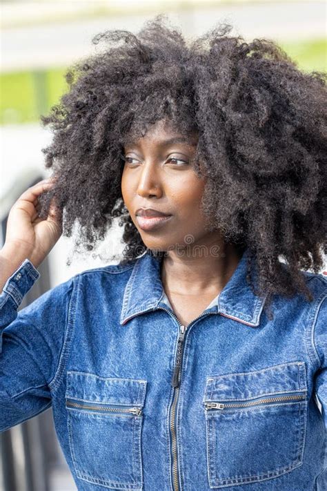 Stylish Woman With Natural Hair In Denim Jacket Confidently Posing