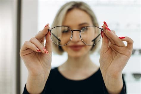 Premium Photo Woman Choosing A Pair Of Eyeglasses At Optics Store