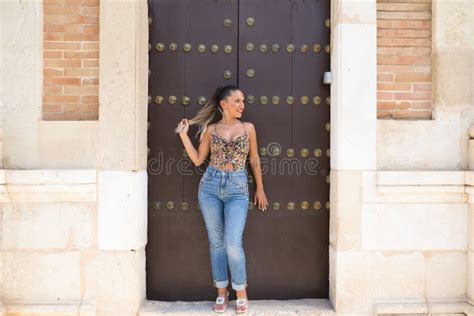 Pretty Young Blonde Spanish Woman Touches Her Hair While Looking To
